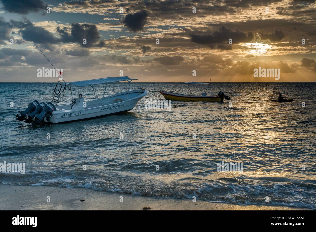 Fishing boats, man in kayak, at sunrise, Caribbean Sea coast in Puerto ...