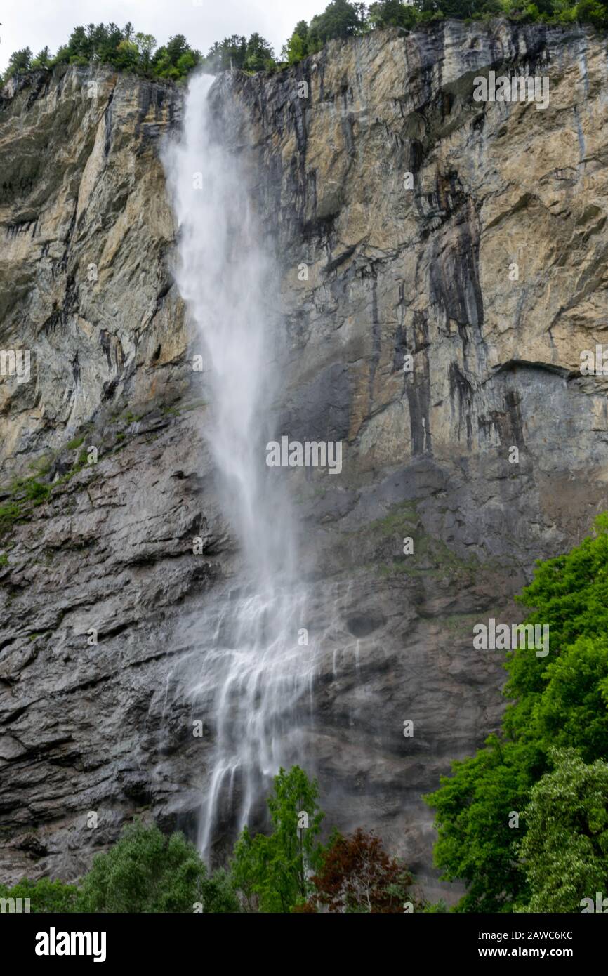 High waterfall (Staubbach) falling from the tall cliff, Lauterbrunnen ...