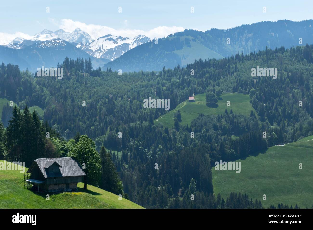 Single house in the Alps mountains with Snow peaks on the background ...