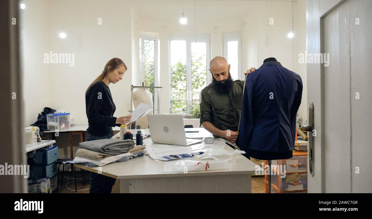 A tailor in a sewing workshop at work. His Studio is Sunny. Colored ...