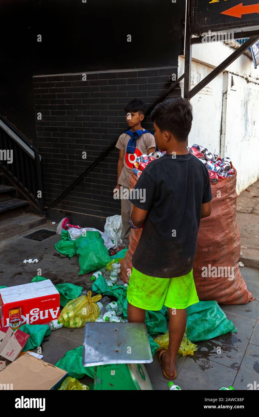 Young Asian men are weighing sacks filled with recyclable aluminum cans ...