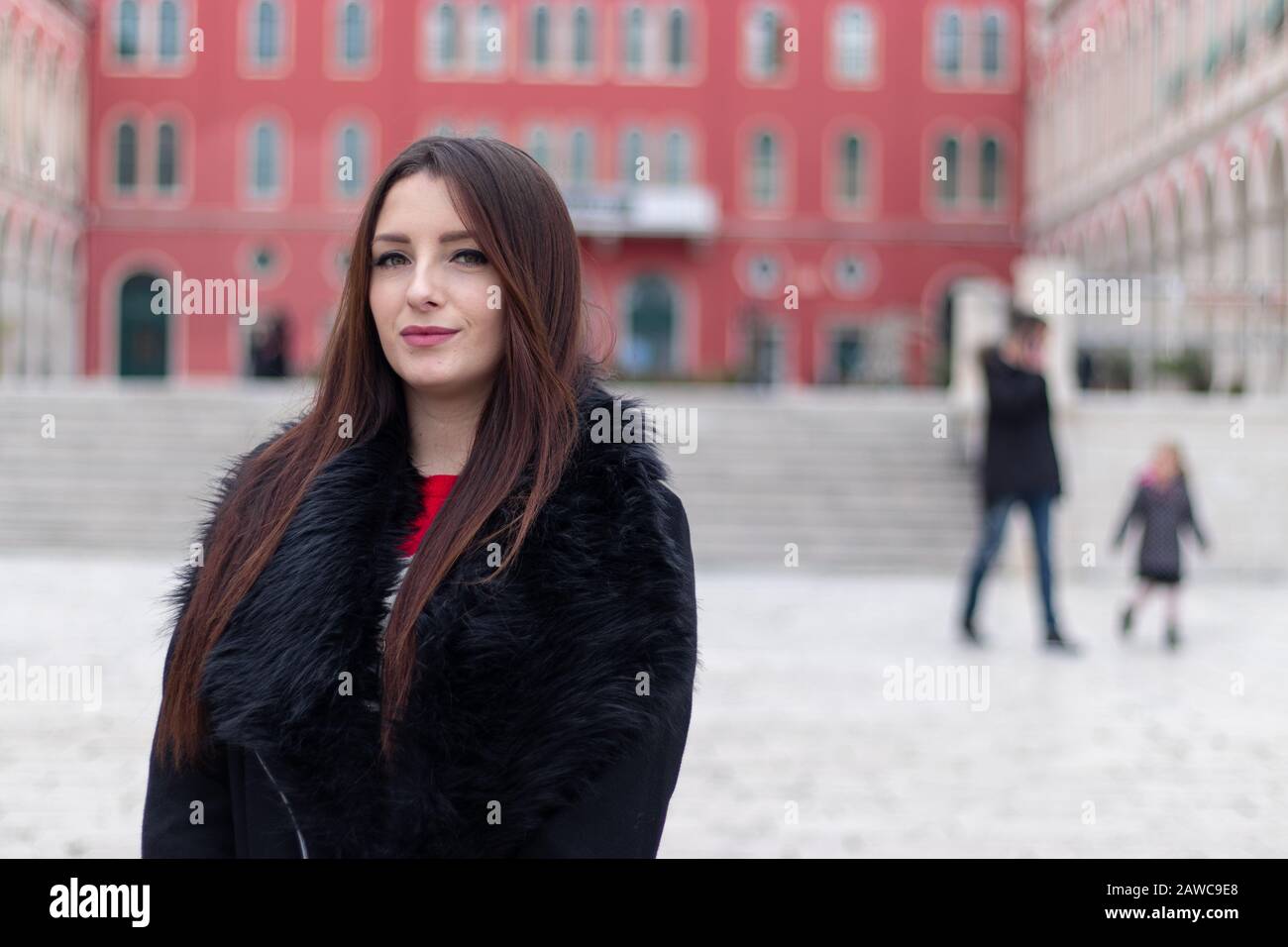 Confident attractive brunette standing in public , "Prokurative" area of Split , Croatia in the ...