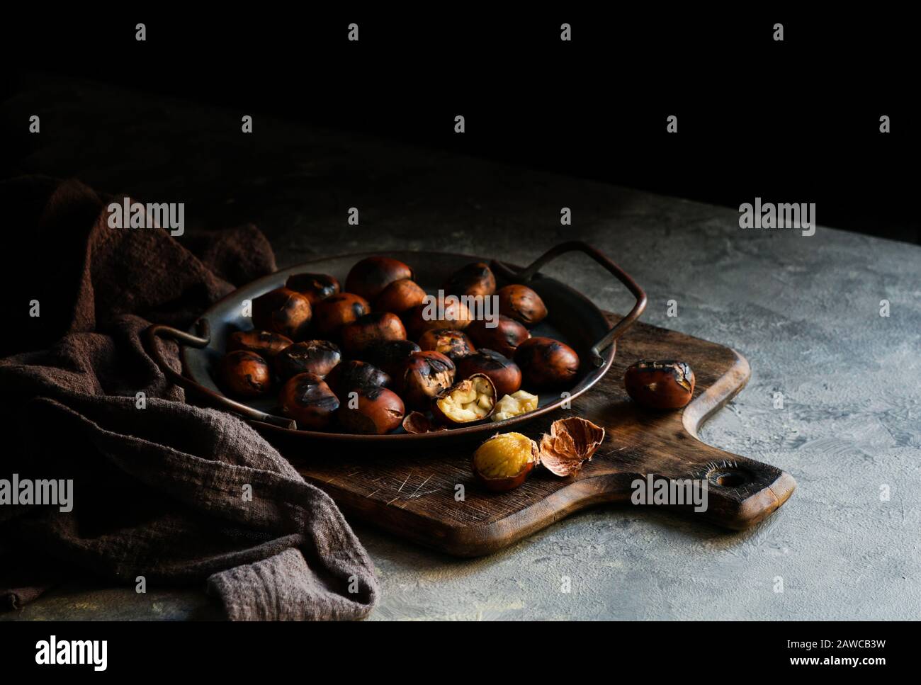baked chestnuts, fried on the grey dark background, ready to eat, copy ...