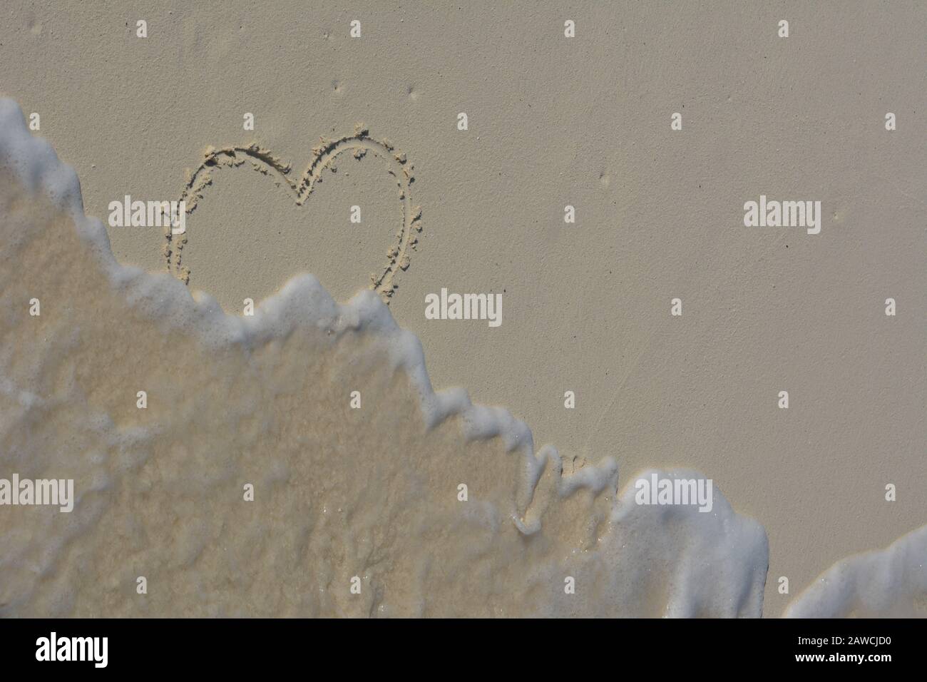 Heart wrote in the sand and washed away by waves Stock Photo - Alamy