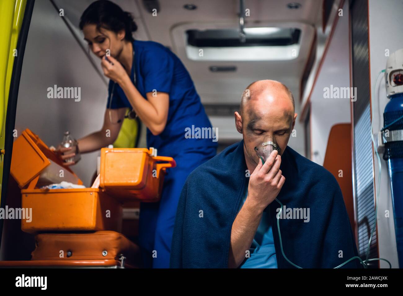 Man breathe through oxygen mask, young nurse in medical uniform opens ...