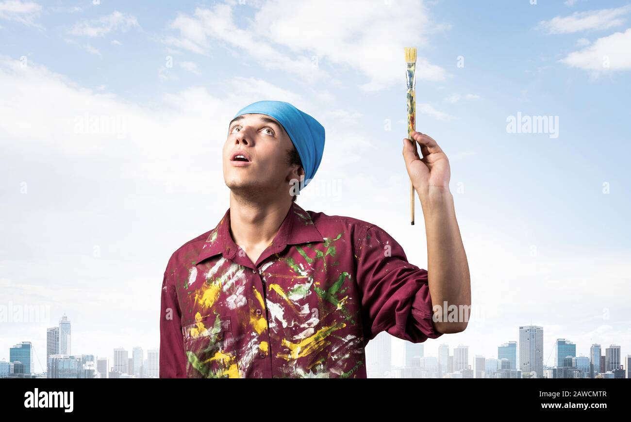 Young painter artist holding paint brush overhead Stock Photo - Alamy