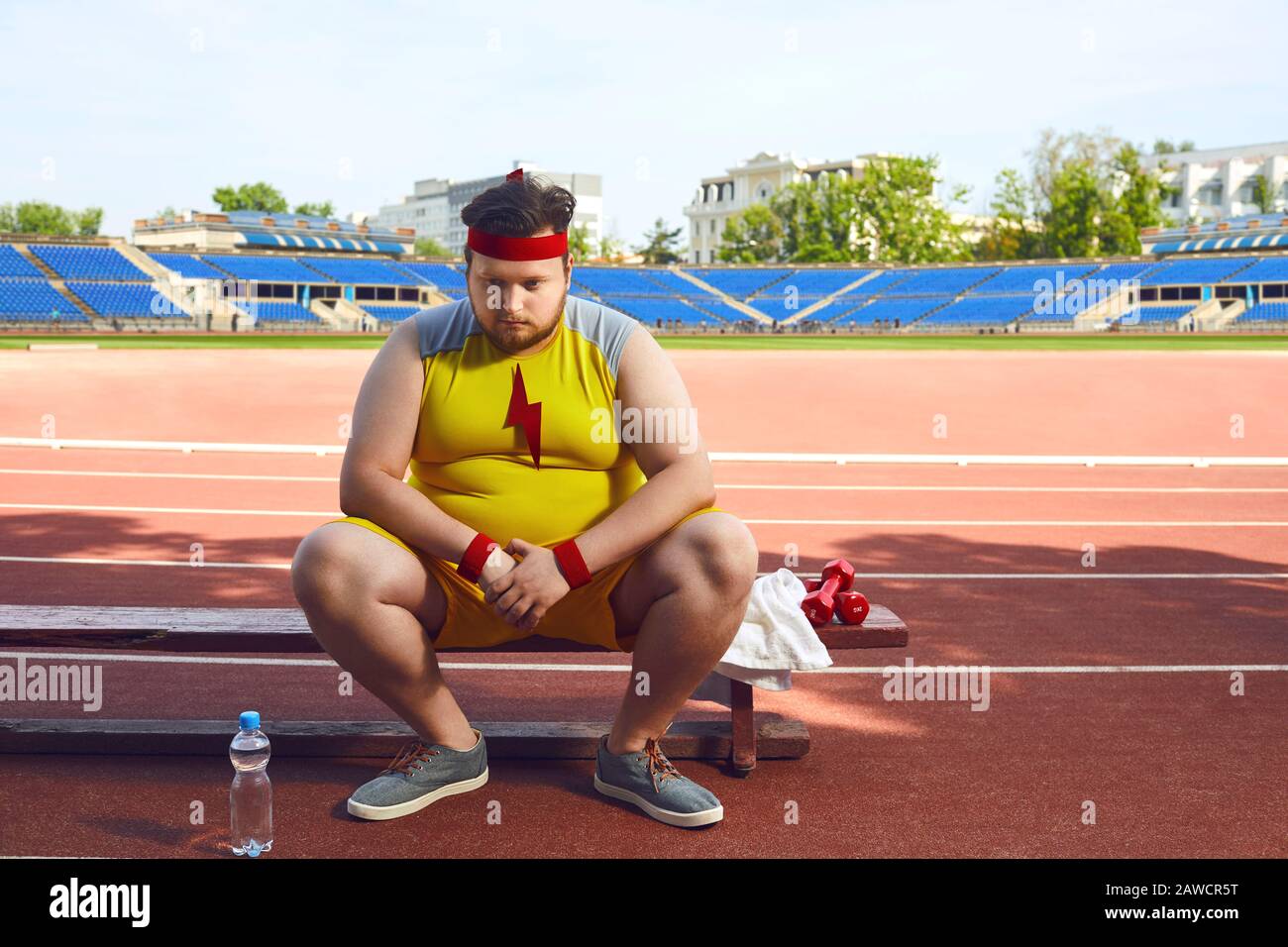 Fat sad man sitting in a stadium after training Stock Photo - Alamy