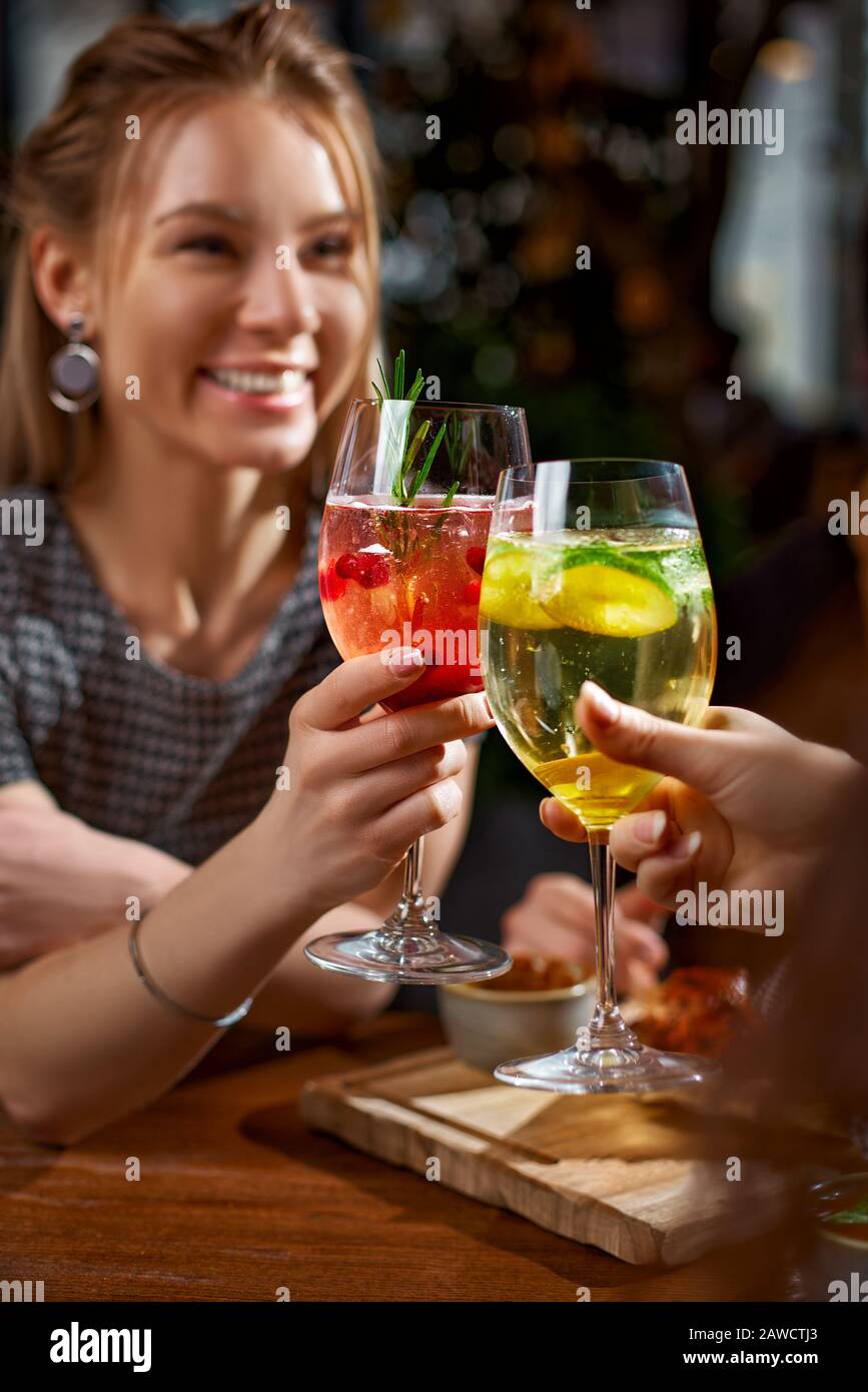 Two girls drink cocktails with ice red and yellow colors. Extremely ...