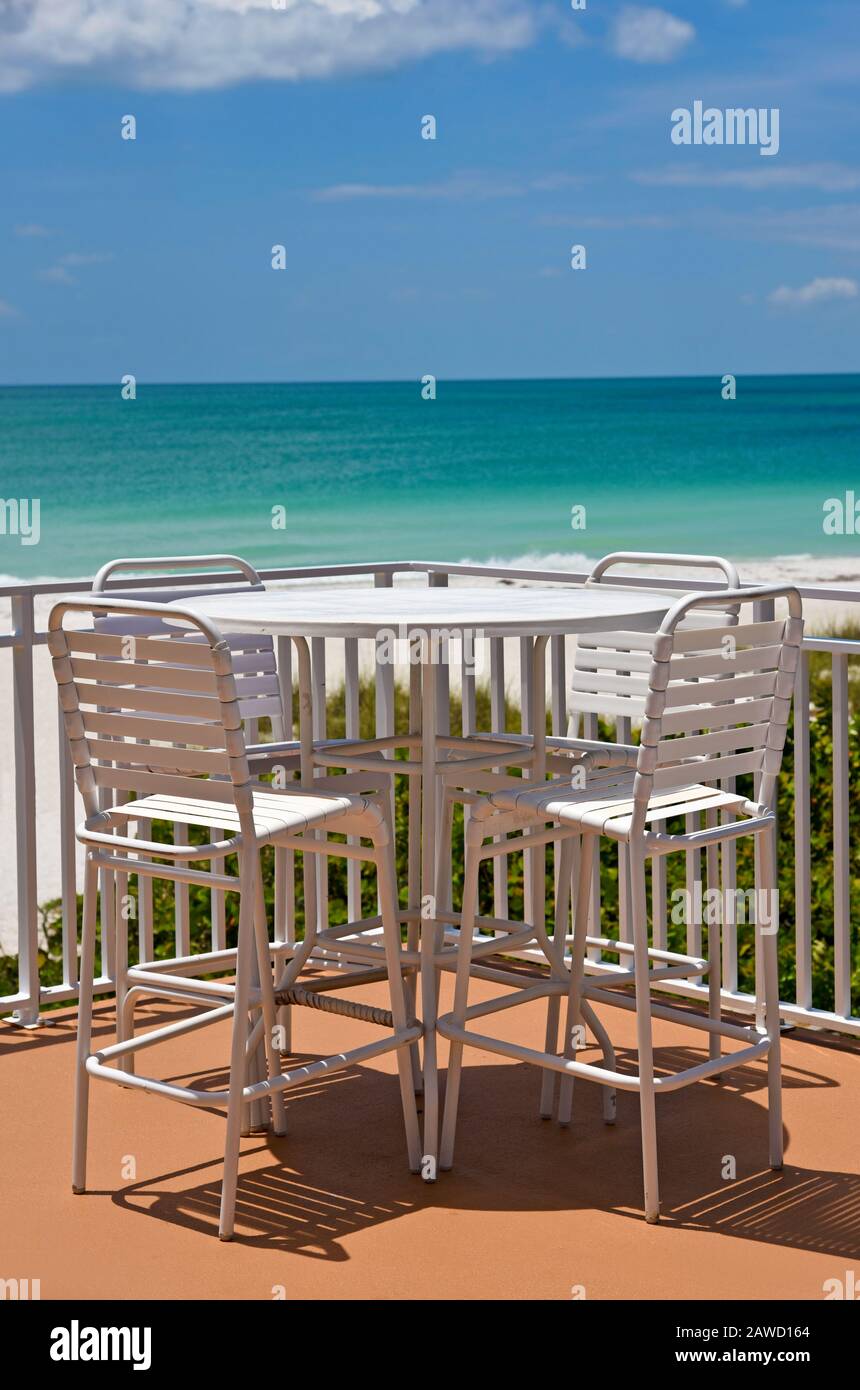 Outdoor Table and Chairs on a Patio overlooking white sandy beach on ...
