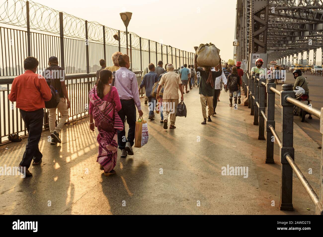 Indian people walk on Howrah bridge, some people with heavy baggages on ...