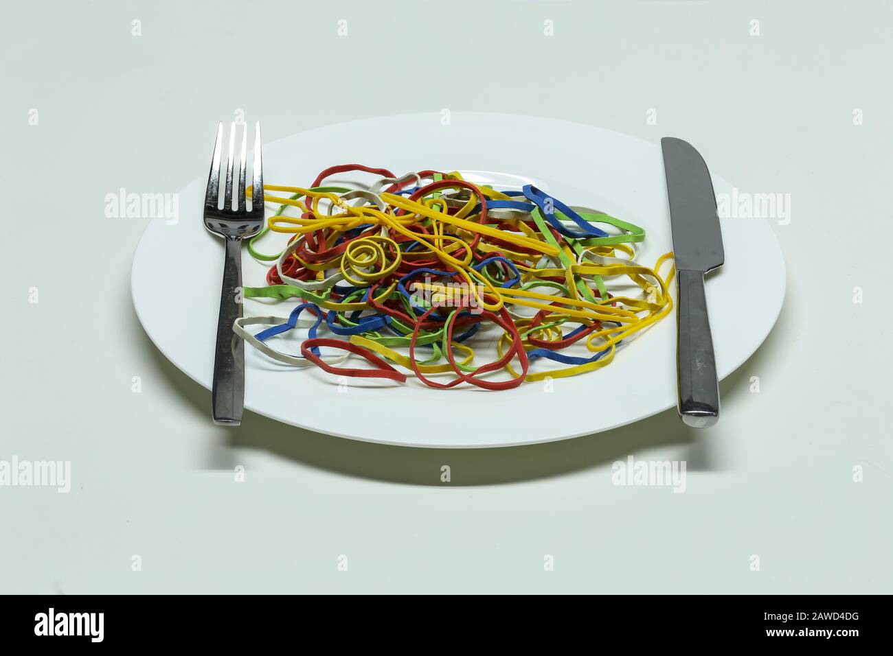Elastic multi-colored rubber bands lie in a plate like spaghetti Stock ...