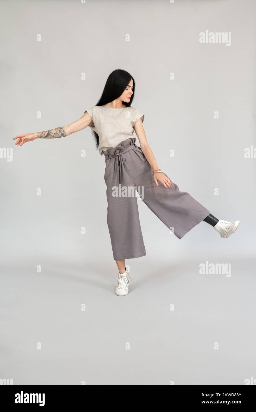 Freestyle. Diverse girl with leg prosthesis standing leg aside isolated ...