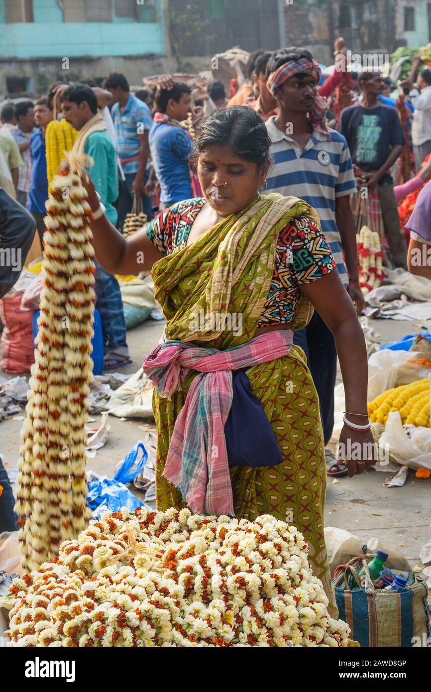 Indian woman trader with flower garland on Flower market at Mallick ...