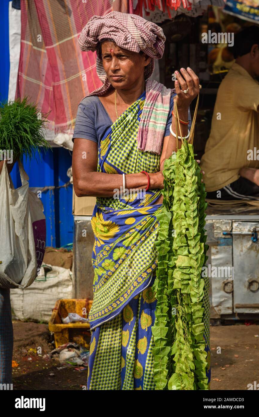 Indian seller woman with leaves garland on Flower market at Mallick ...