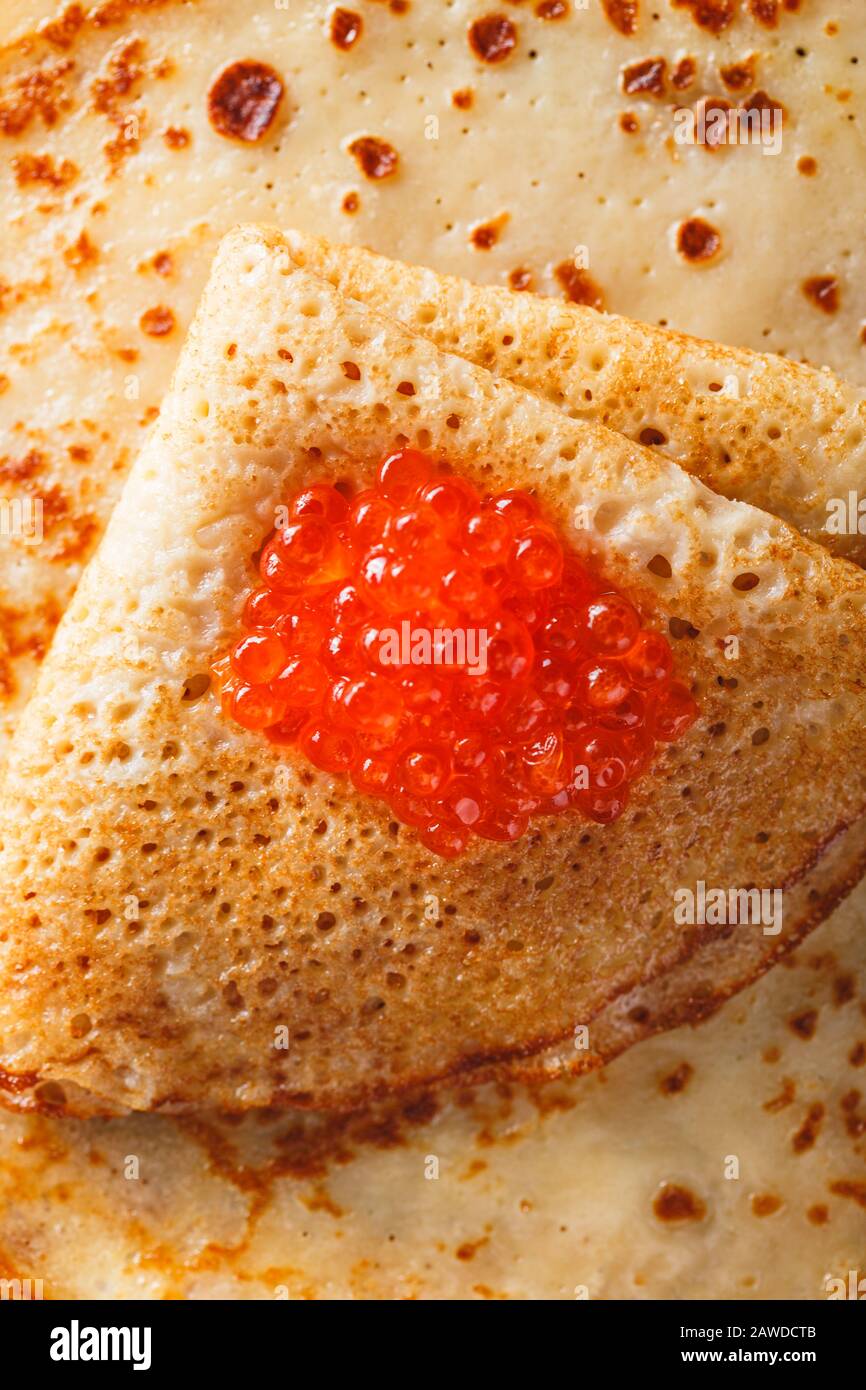 Traditional Russian Crepes Blini stacked in a plate with red caviar on ...