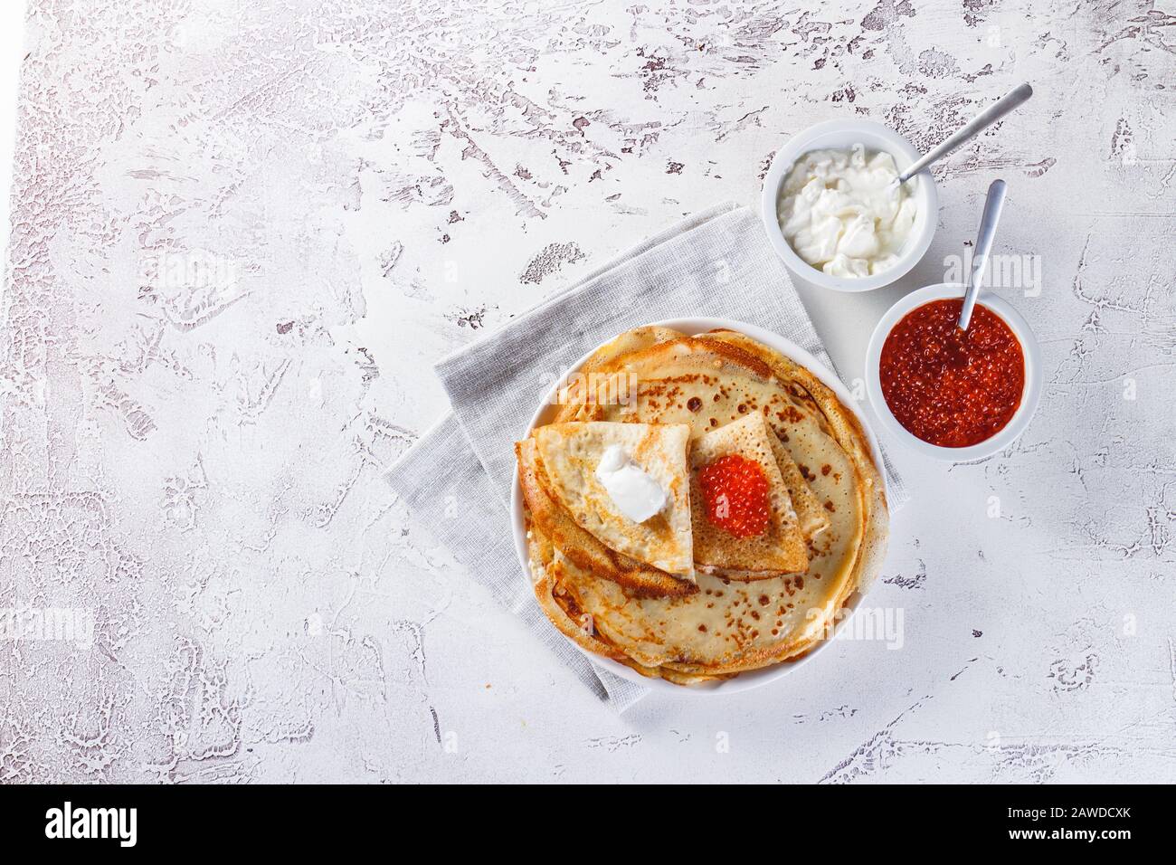 Traditional Russian Crepes Blini stacked in a plate with red caviar ...