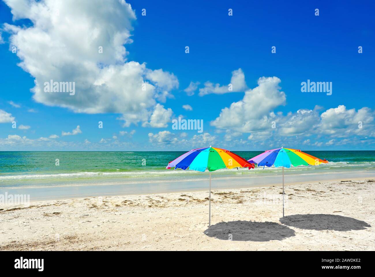 Two Rainbow Colored Beach Umbrellas on the Beach Stock Photo - Alamy