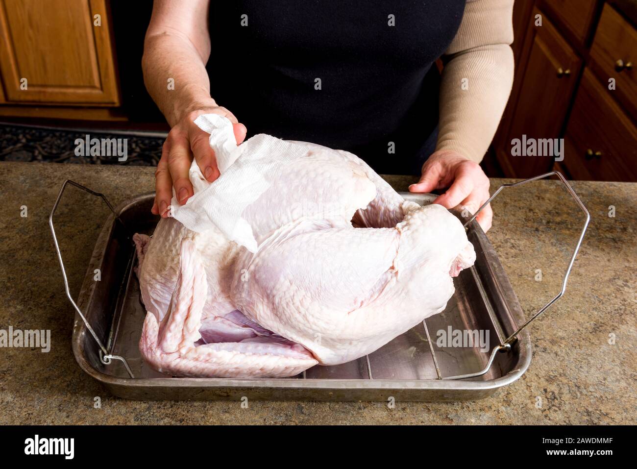 A turkey being wiped down on a pan for preparation Stock Photo - Alamy