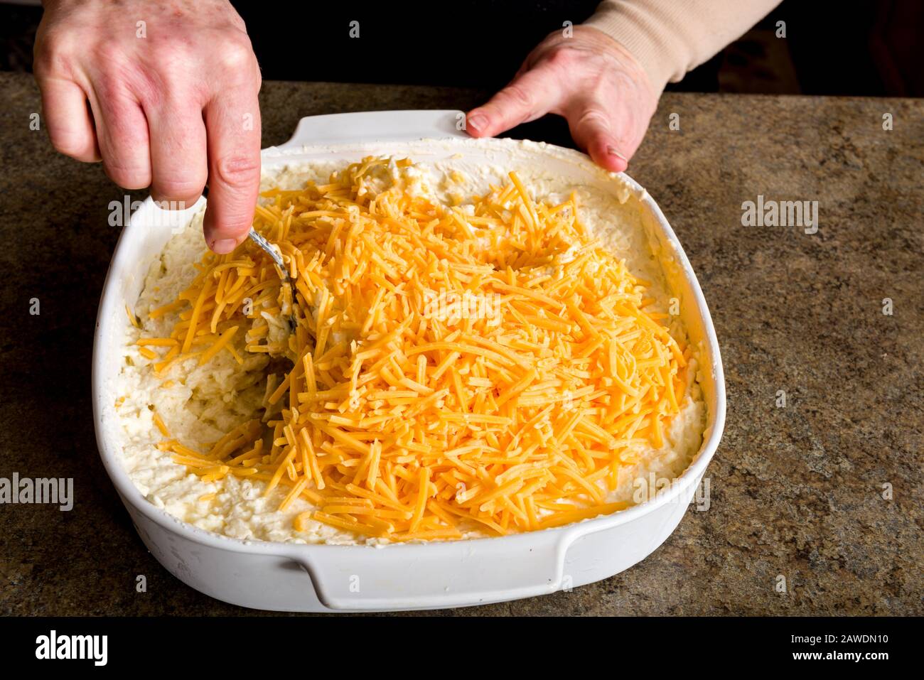 Mashed potato being mixed with cheese to make cheesy potatoes Stock ...