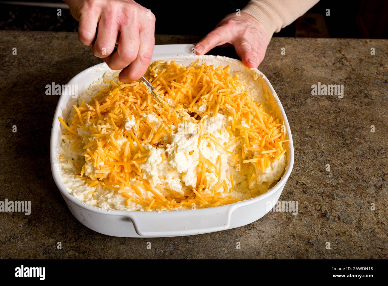 Mashed potato being mixed with cheese to make cheesy potatoes Stock ...