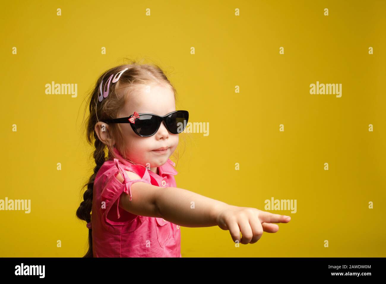 Little girl in dress and sunglasses indicating the direction Stock ...