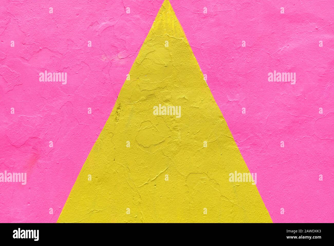 Abstract plaster texture of a yellow triangle on a pink background ...