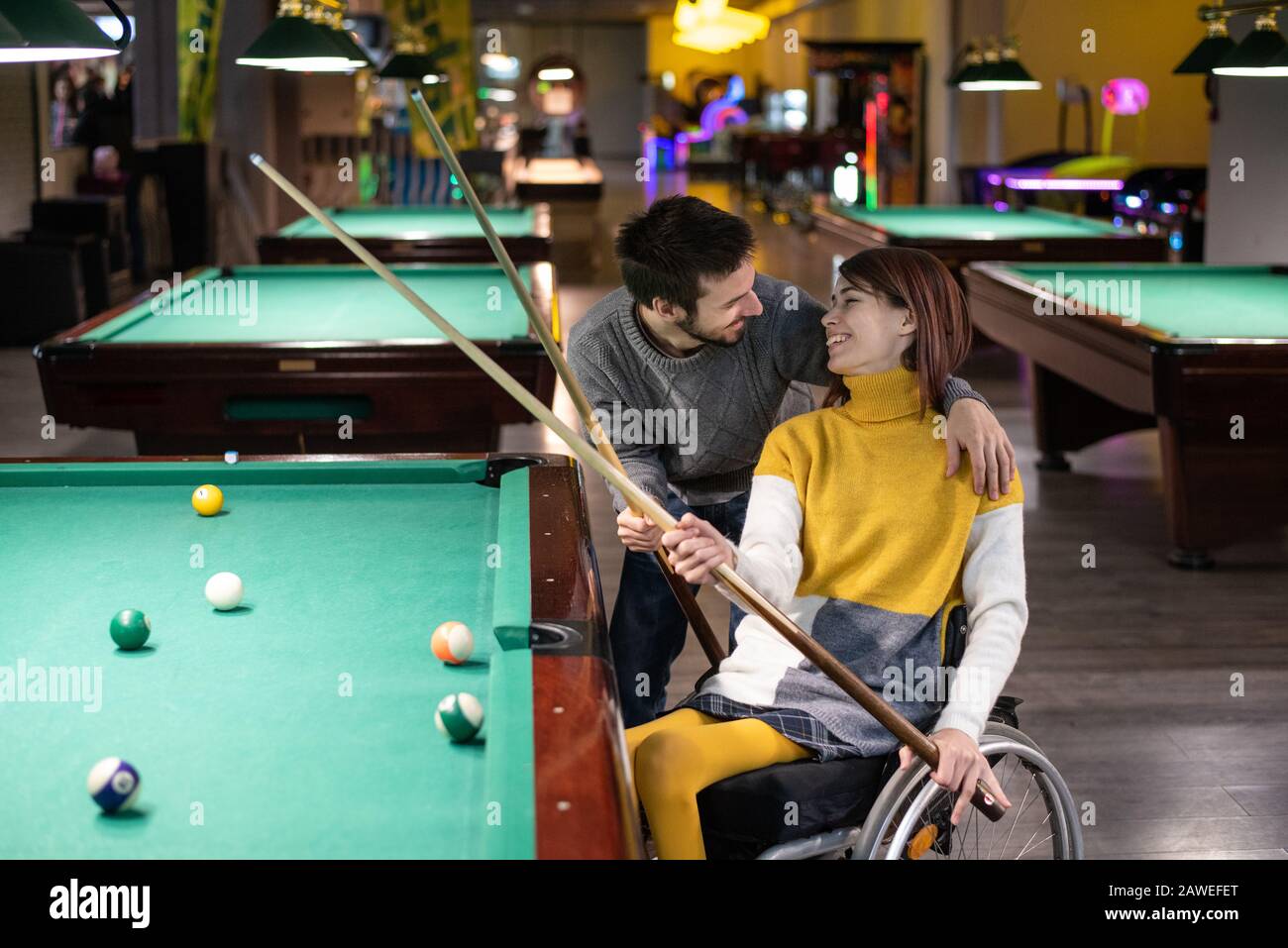 Beautiful disabled girl in a wheelchair playing billiards with her ...