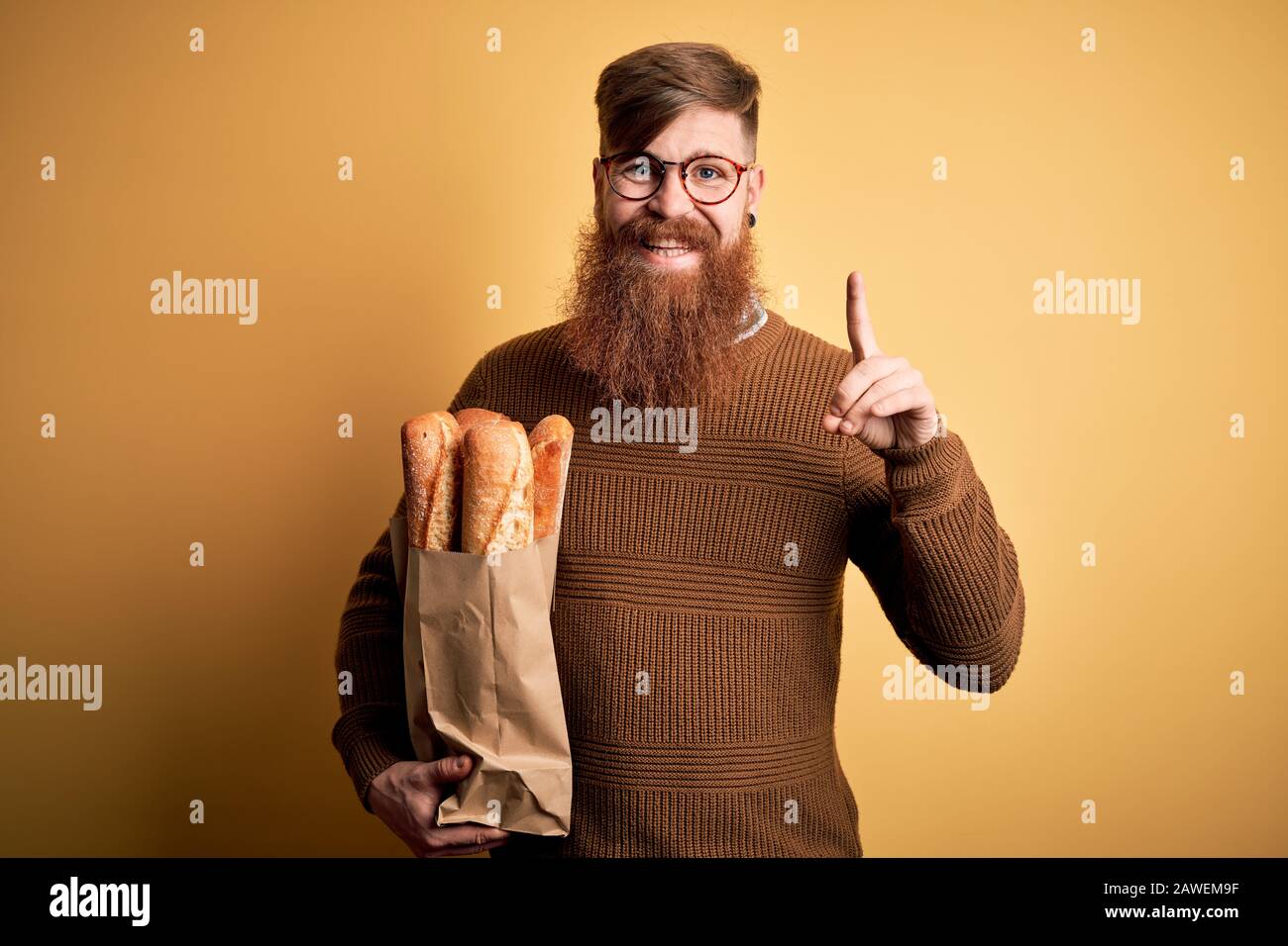Irish redhead man with beard holding groceries paper bag of bread over ...