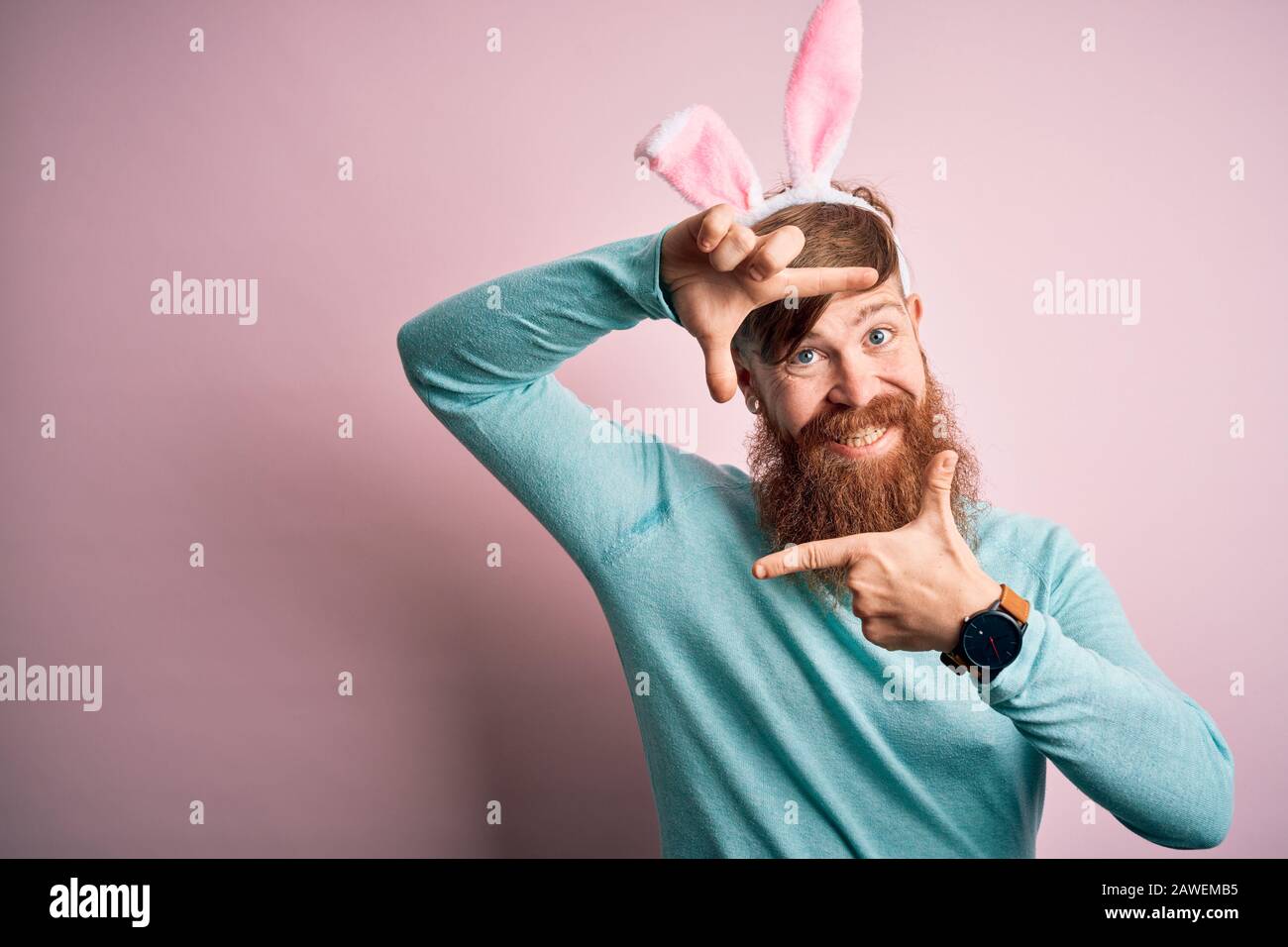 Hipster Irish man with beard wearing easter rabbit ears over isolated ...
