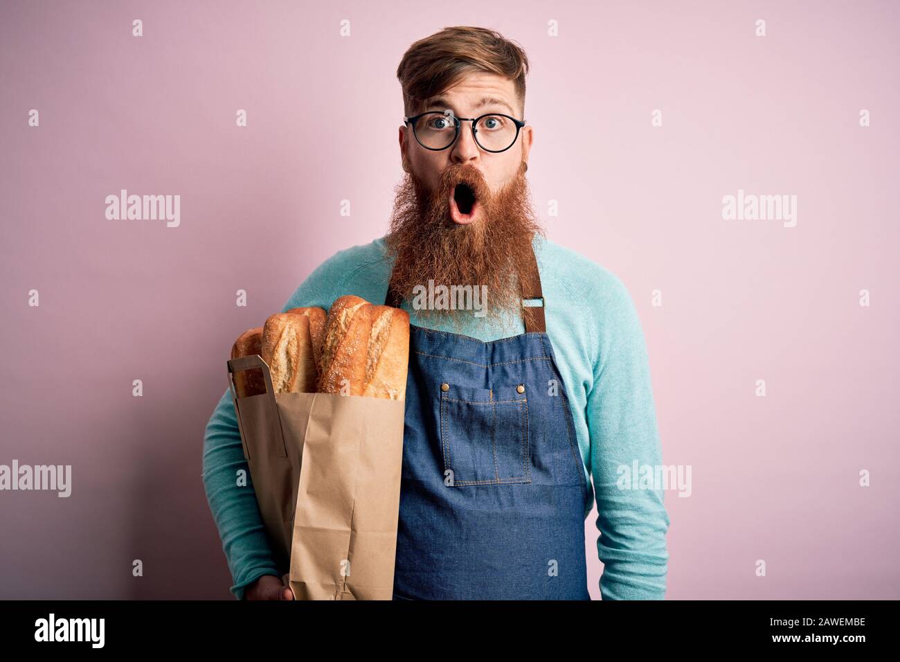 Irish redhead baker man with beard holding groceries paper bag of bread ...