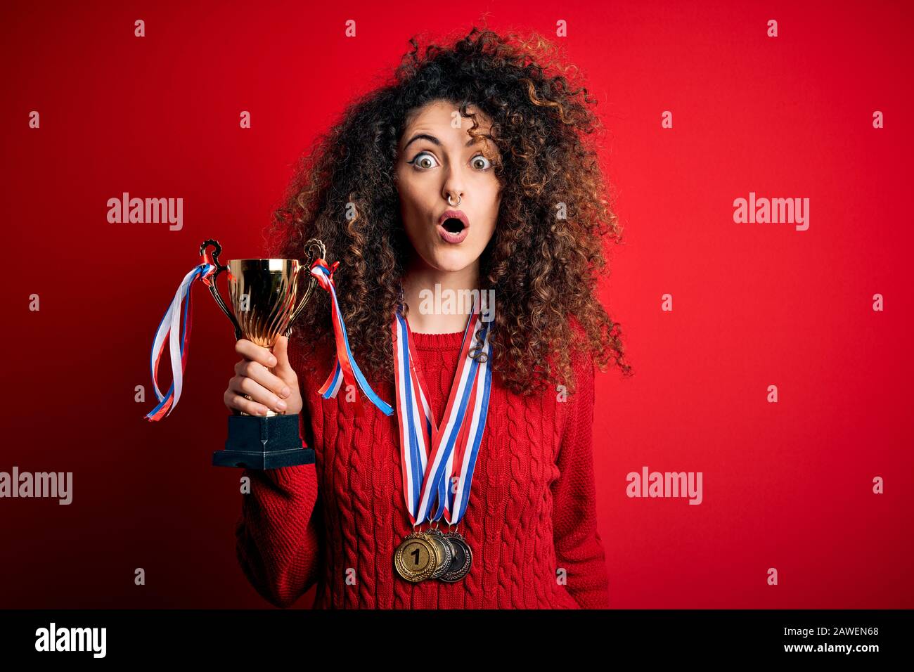 Young beautiful successful woman with curly hair and piercing holding ...