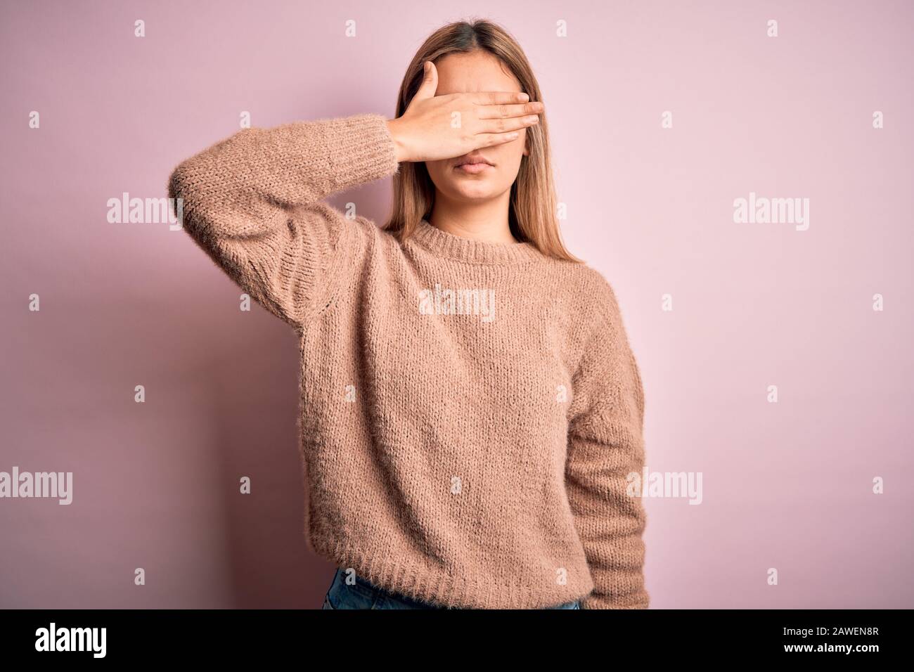 Young beautiful blonde woman wearing winter wool sweater over pink ...