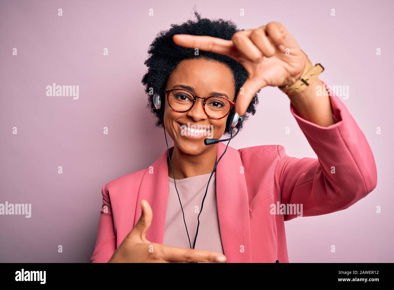Young African American call center operator woman with curly hair using ...