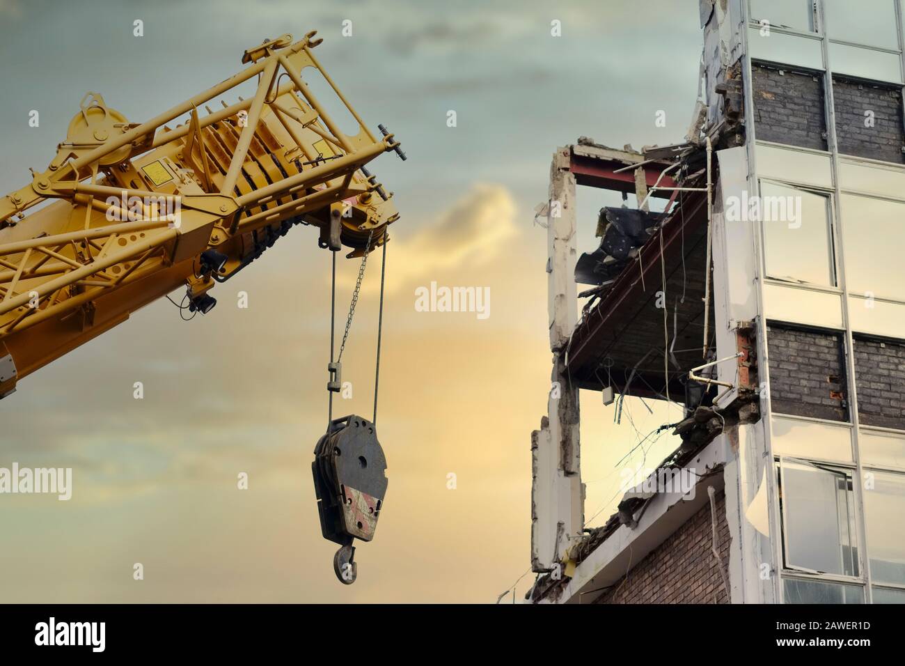 Crane lifting hook at construction site with derelict building for ...