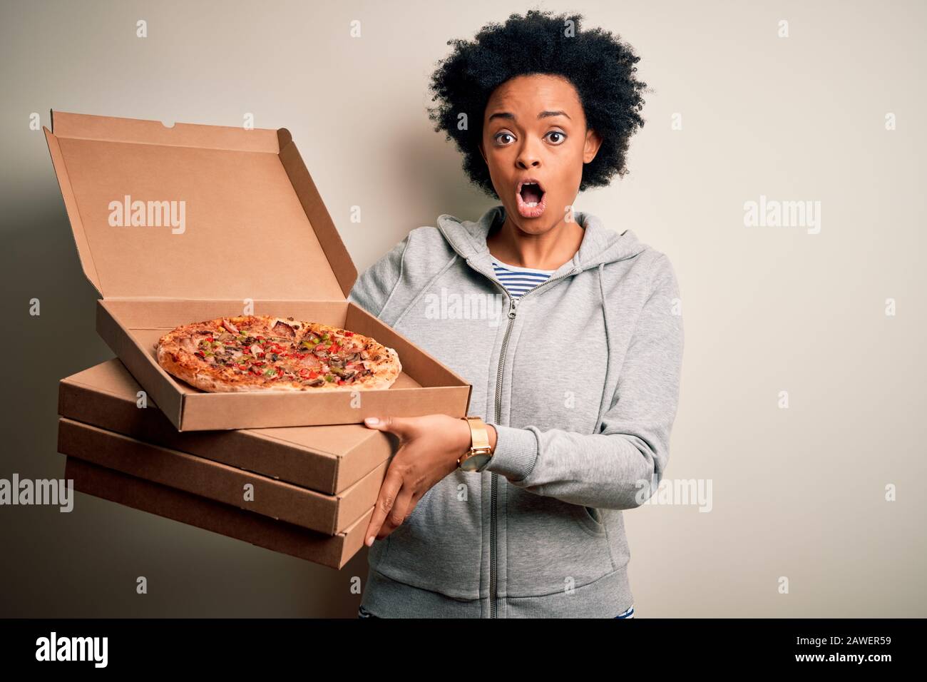 Young African American afro woman with curly hair holding delivery ...