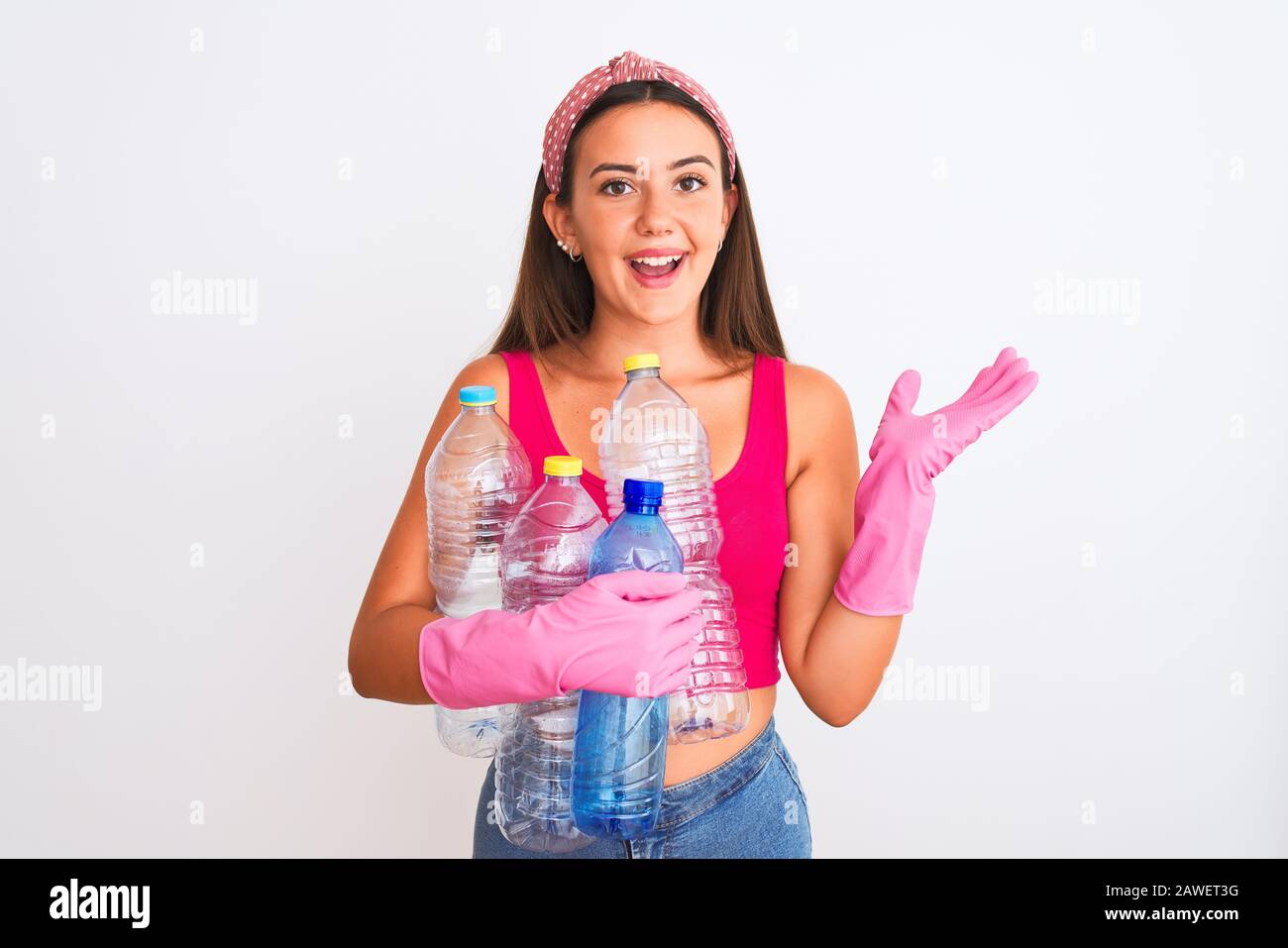 Beautiful girl wearing cleaner gloves recycling plastic bottles over ...