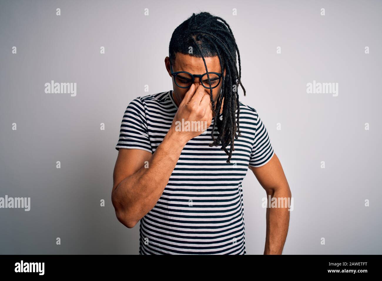 Young handsome african american man with dreadlocks wearing striped t ...