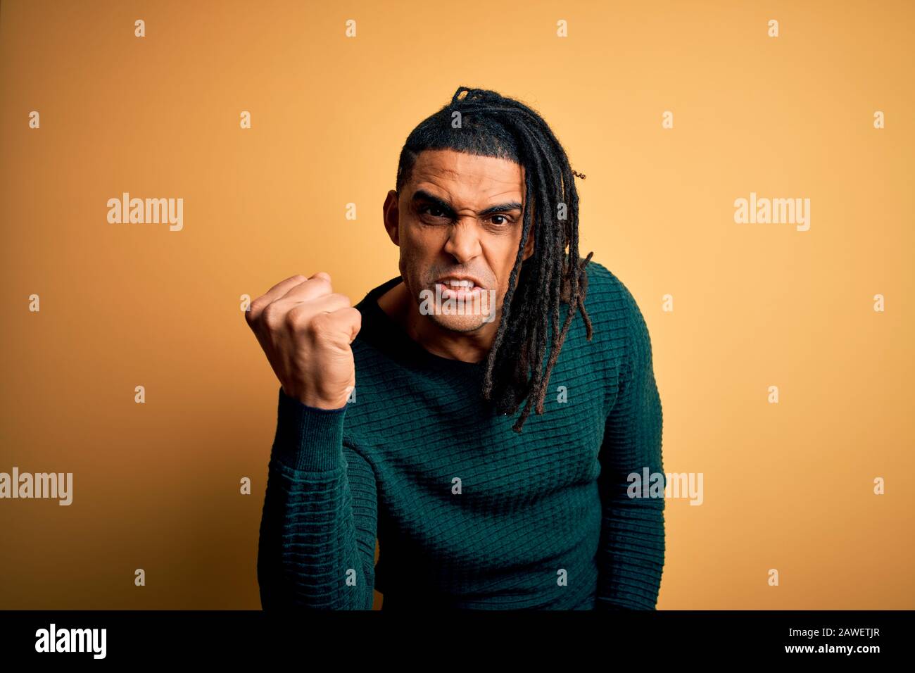 Young handsome african american afro man with dreadlocks wearing green ...
