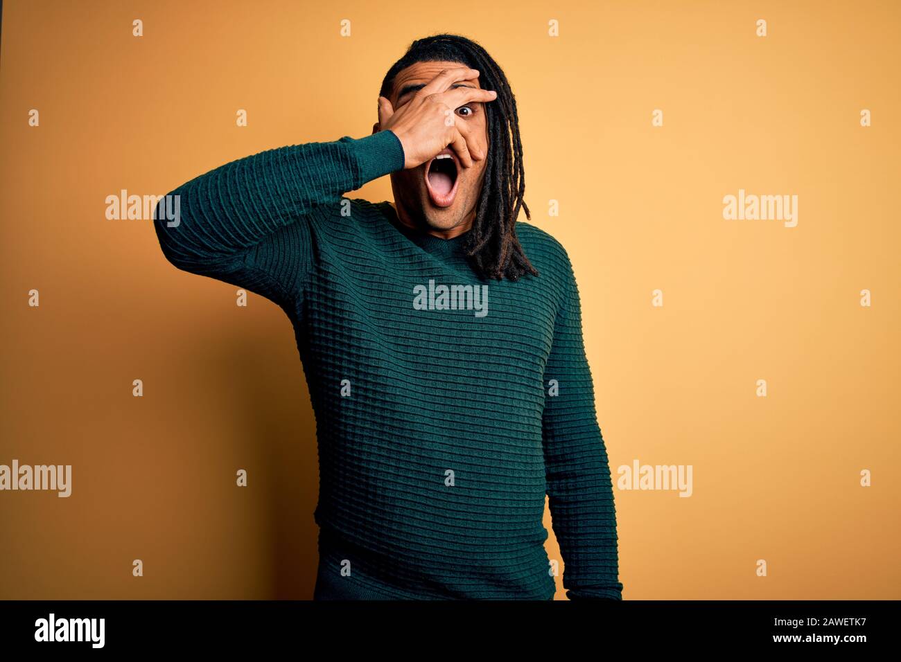Young handsome african american afro man with dreadlocks wearing green ...