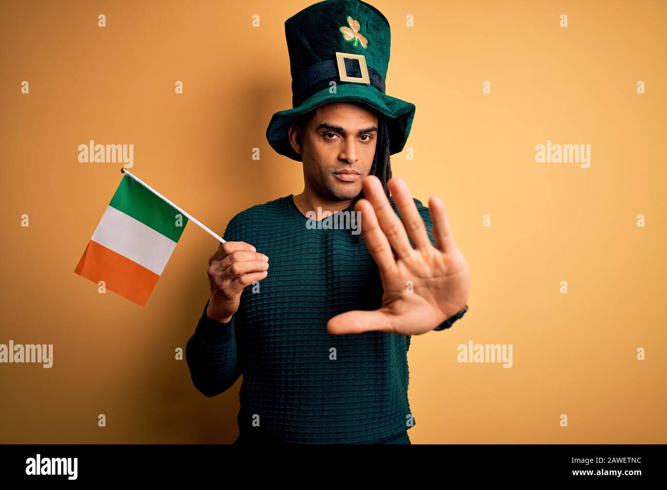 African american man wearing green hat holding irish ireland flag ...