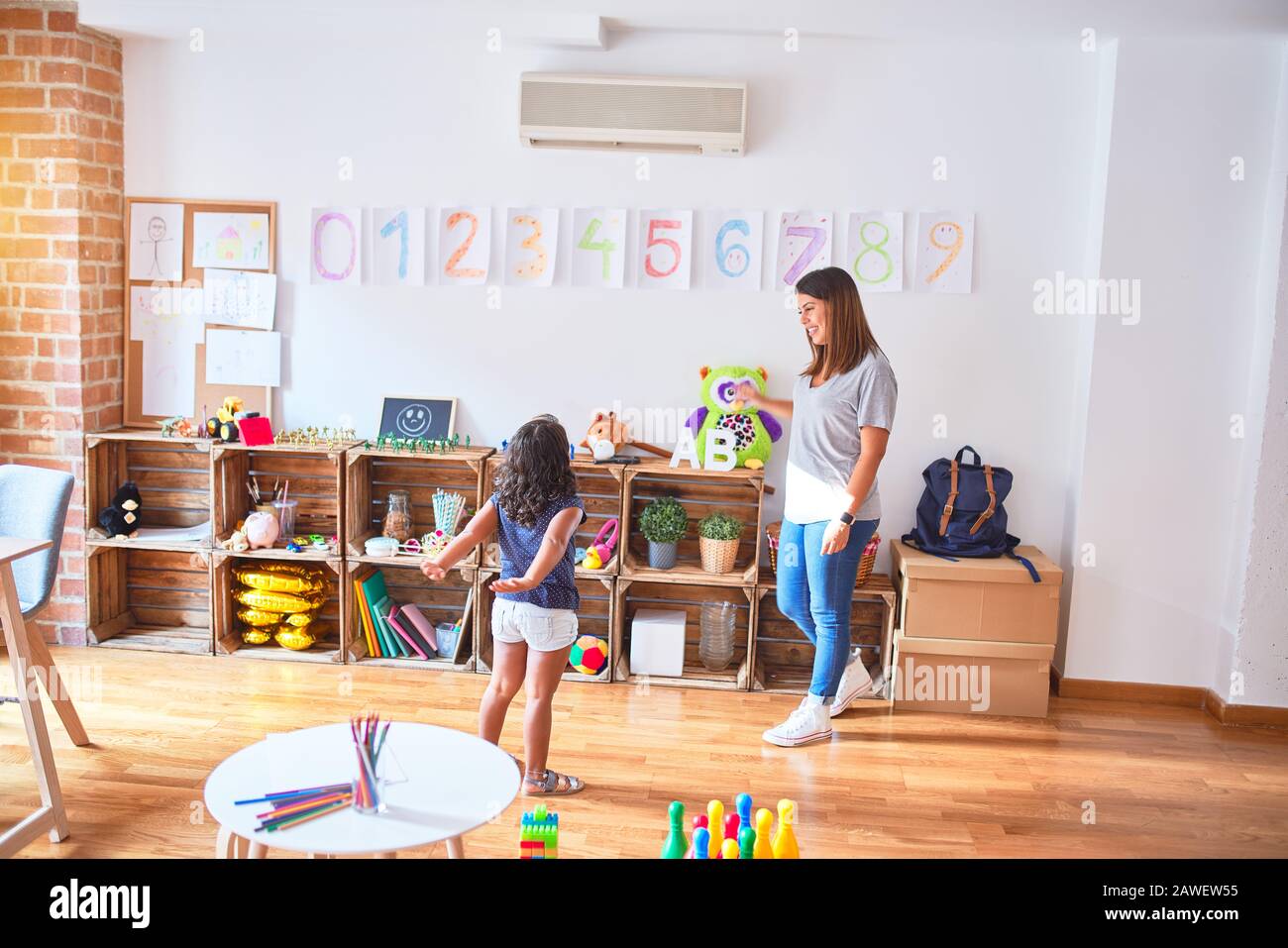 Beautiful teacher teaching maths to toddler girl playing at ...