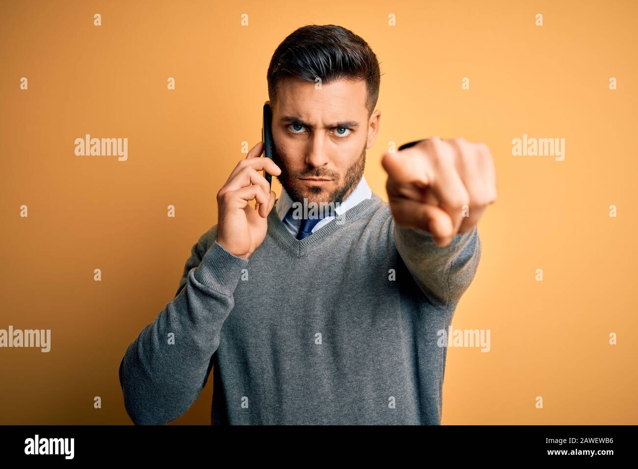 Young handsome man having conversation talking on the smartphone over ...