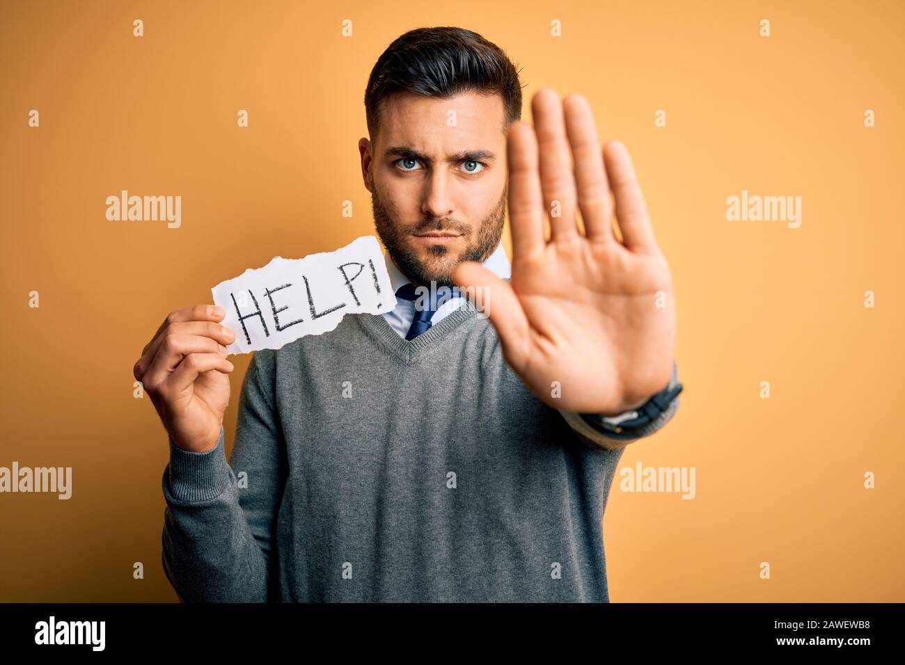 Young overworked business man asking for help holding paper over yellow ...