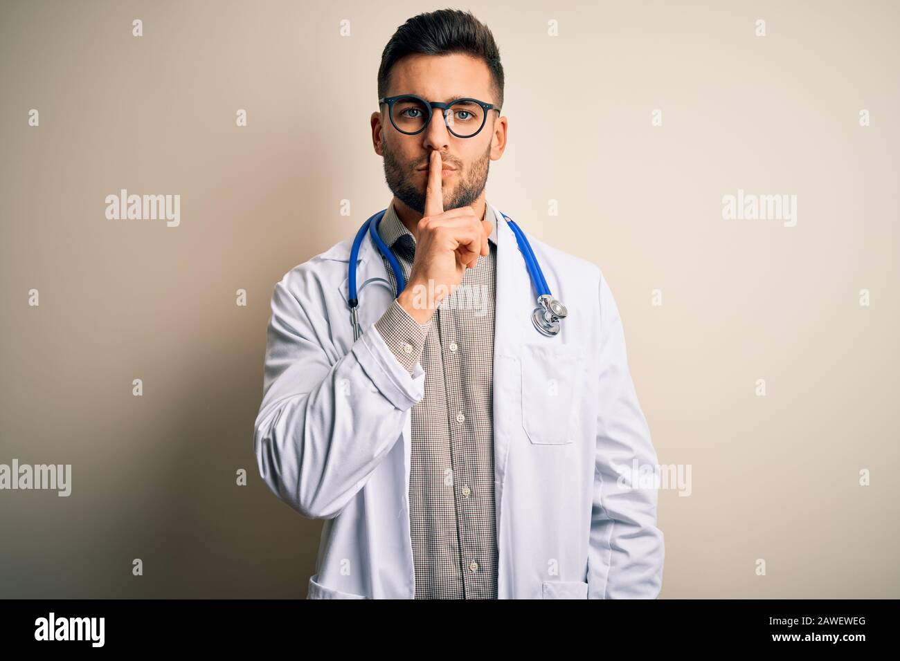 Young doctor man wearing glasses, medical white robe and stethoscope ...
