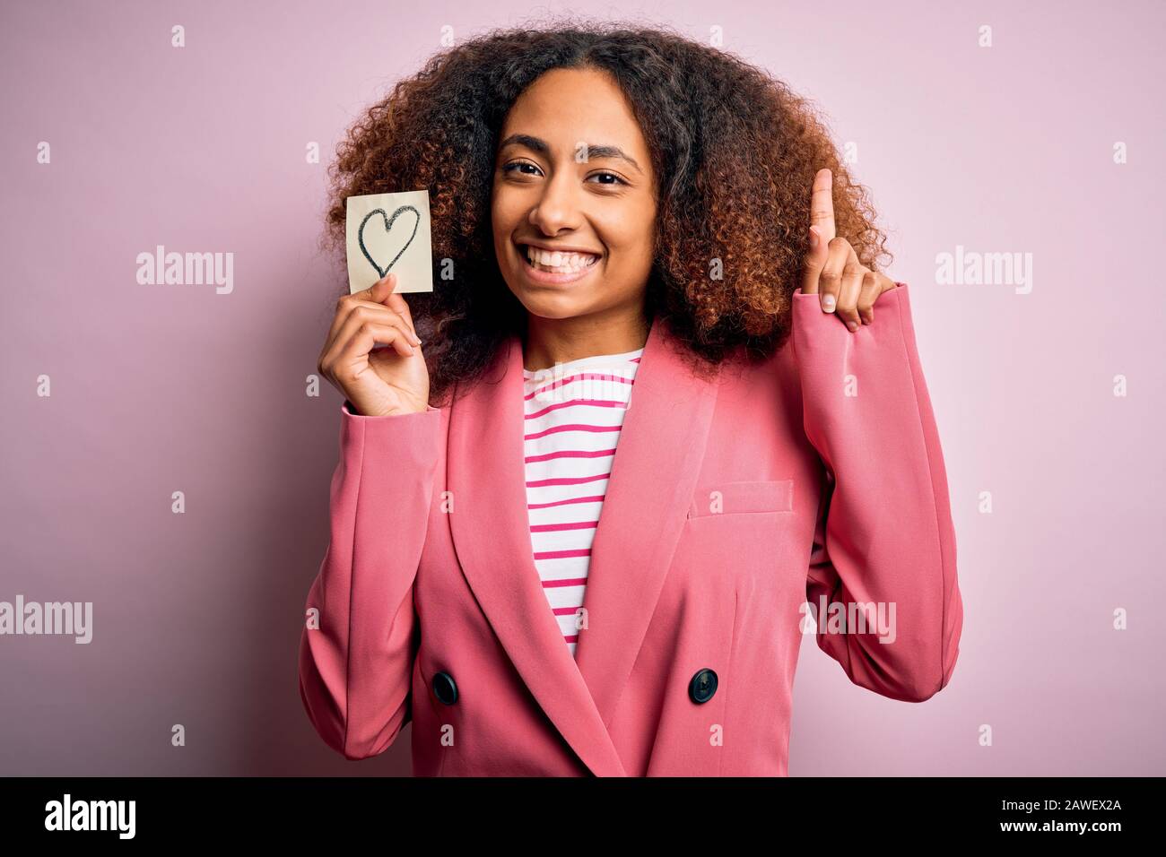 Young african american woman with afro hair holding paper with heart ...