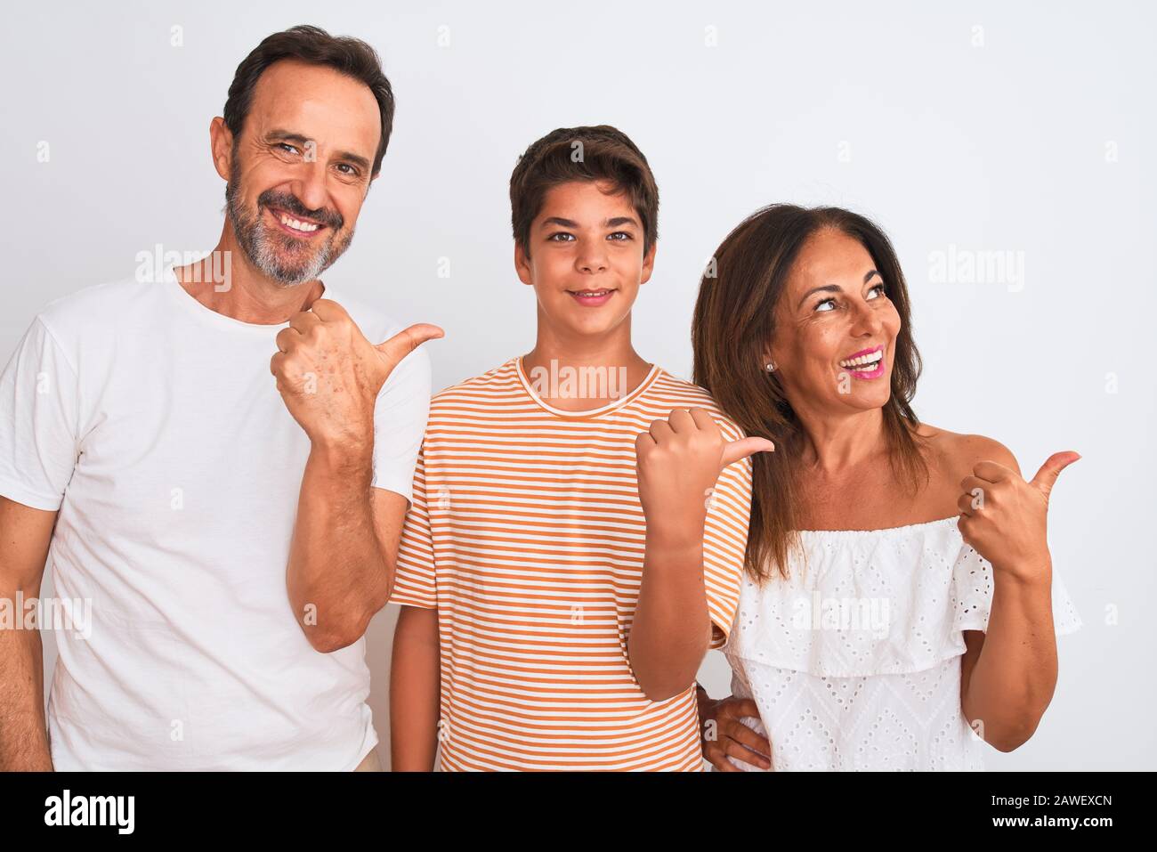 Family of three, mother, father and son standing over white isolated ...