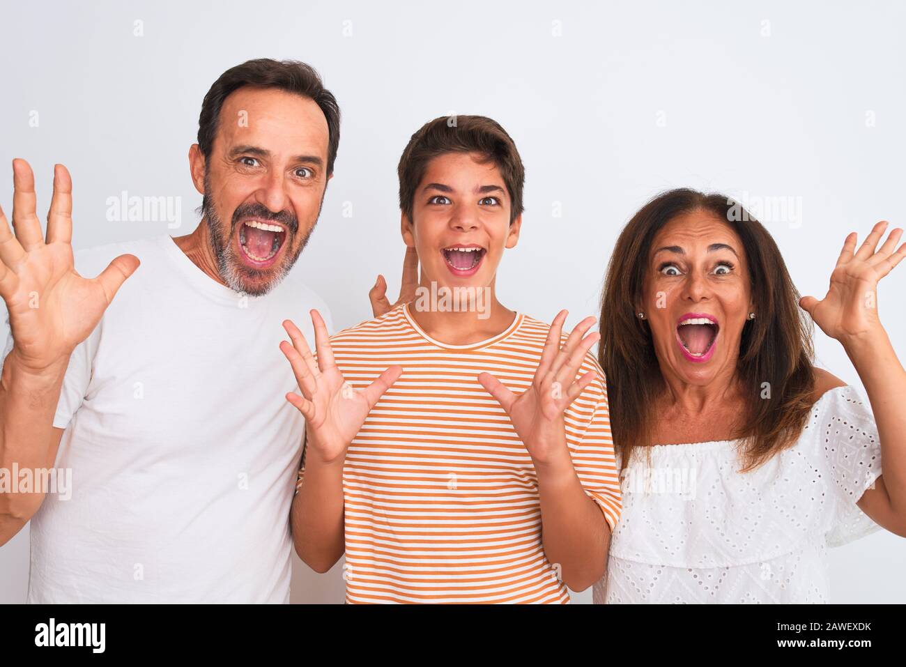 Family of three, mother, father and son standing over white isolated ...