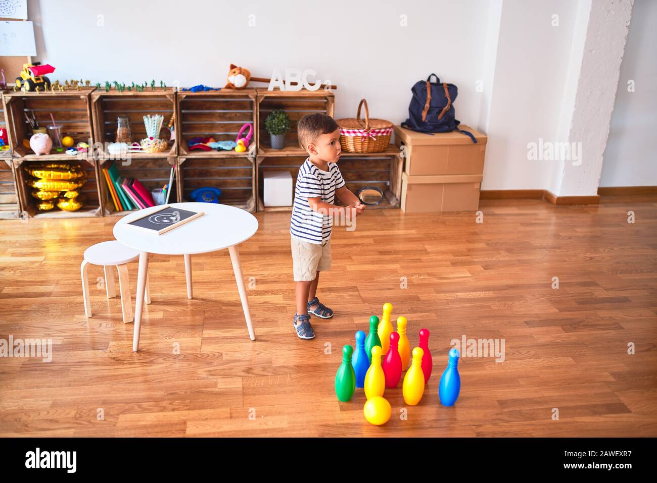 Beautiful toddler boy playing bowling at kindergarten Stock Photo - Alamy