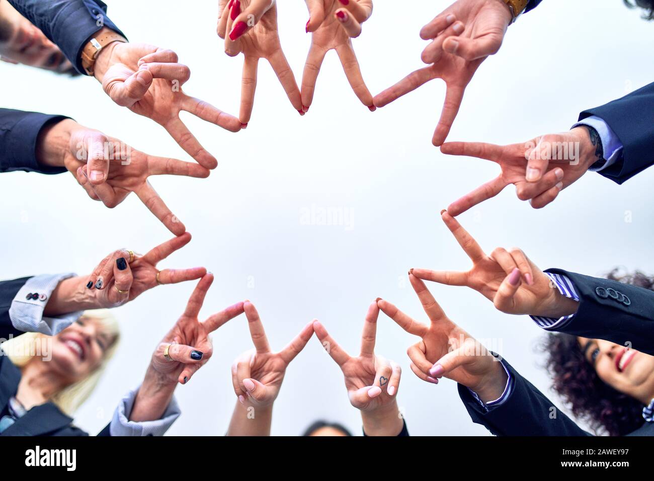 Group of business workers standing doing symbol with fingers together ...