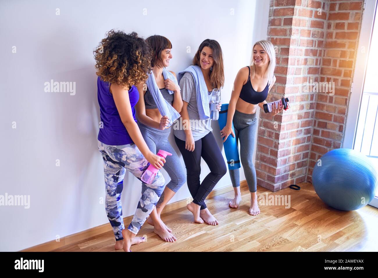 Young beautiful group of sportswomen smiling happy. Standing speaking ...